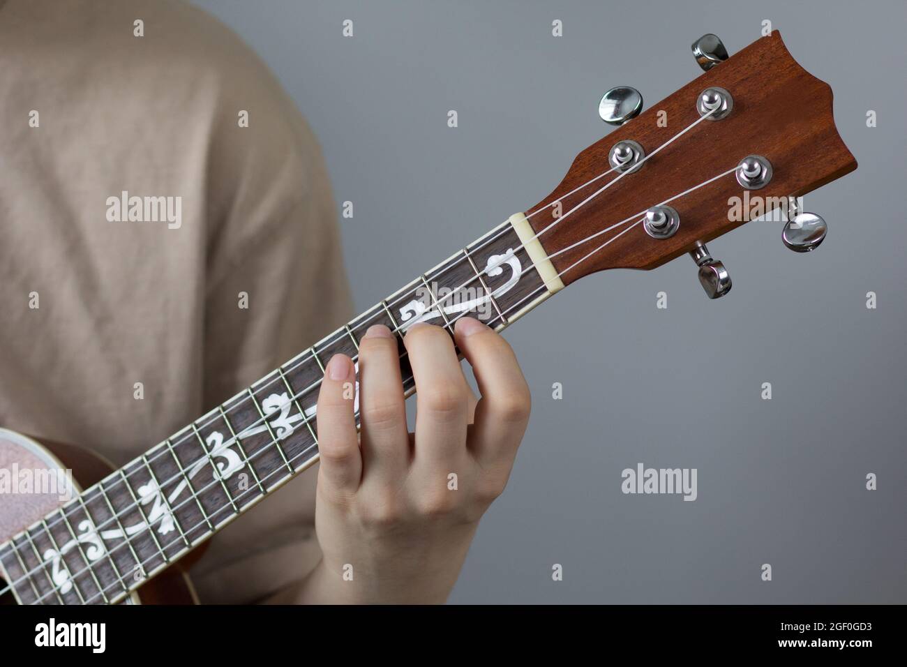 Woman hand playing ukulele on white background Stock Photo - Alamy