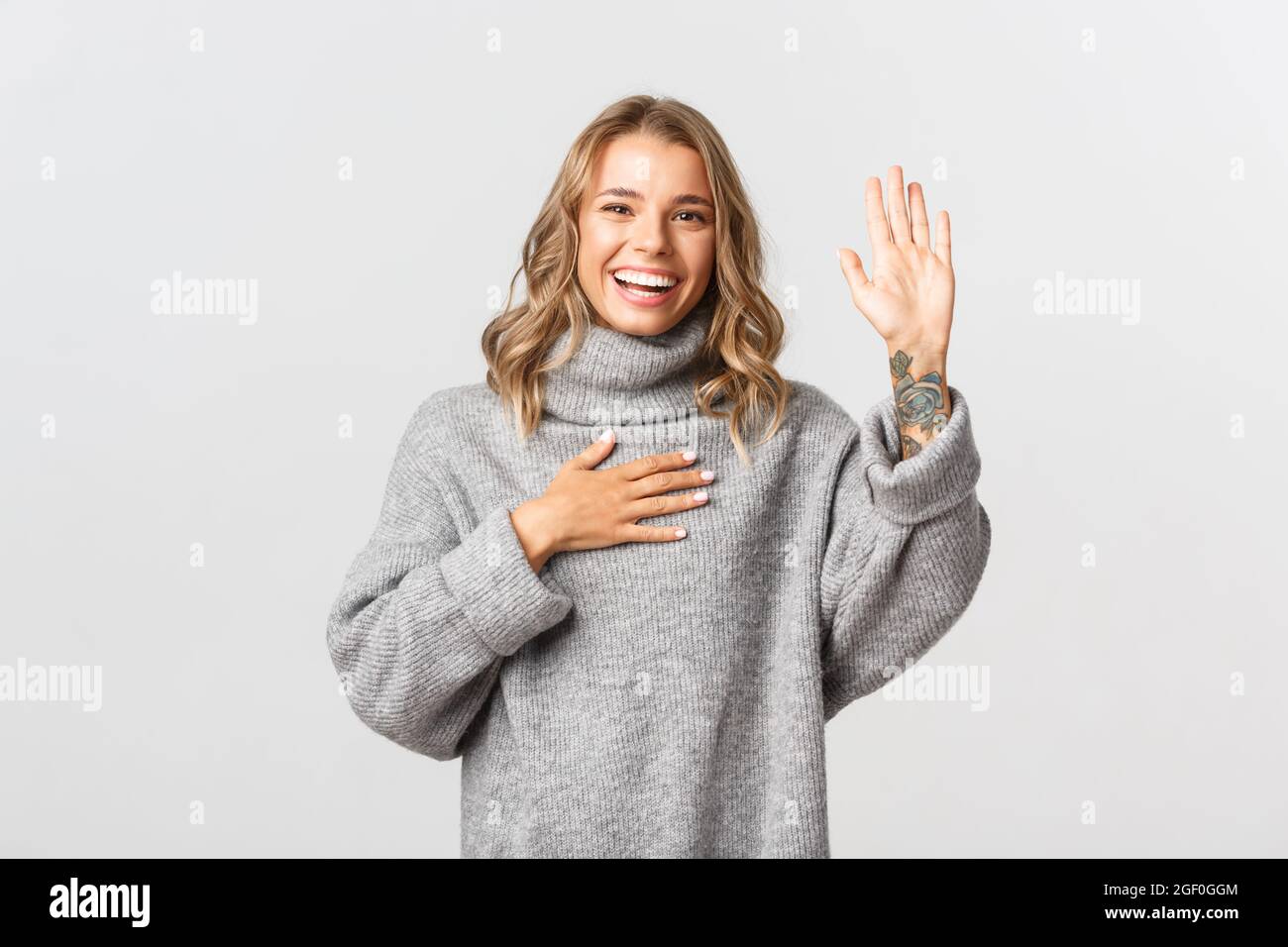 Image of happy honest girl raising one arm and put hand on heart ...