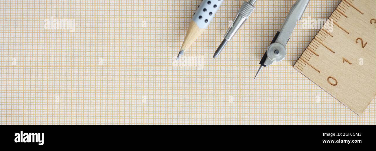 Wooden ruler, compasses and pencil lie on graph paper Stock Photo - Alamy