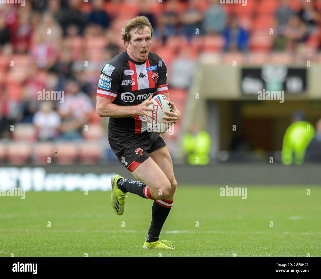 Dan Sarginson (23) of Salford Red Devils runs forward with the ball ...