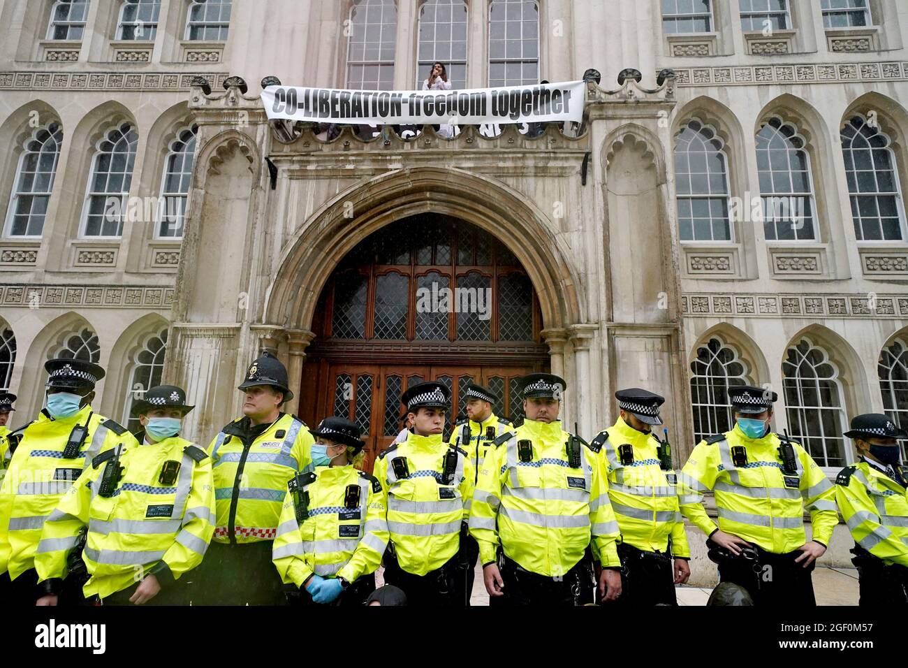 Police officers form a line in front of the entrance to the Guildhall ...