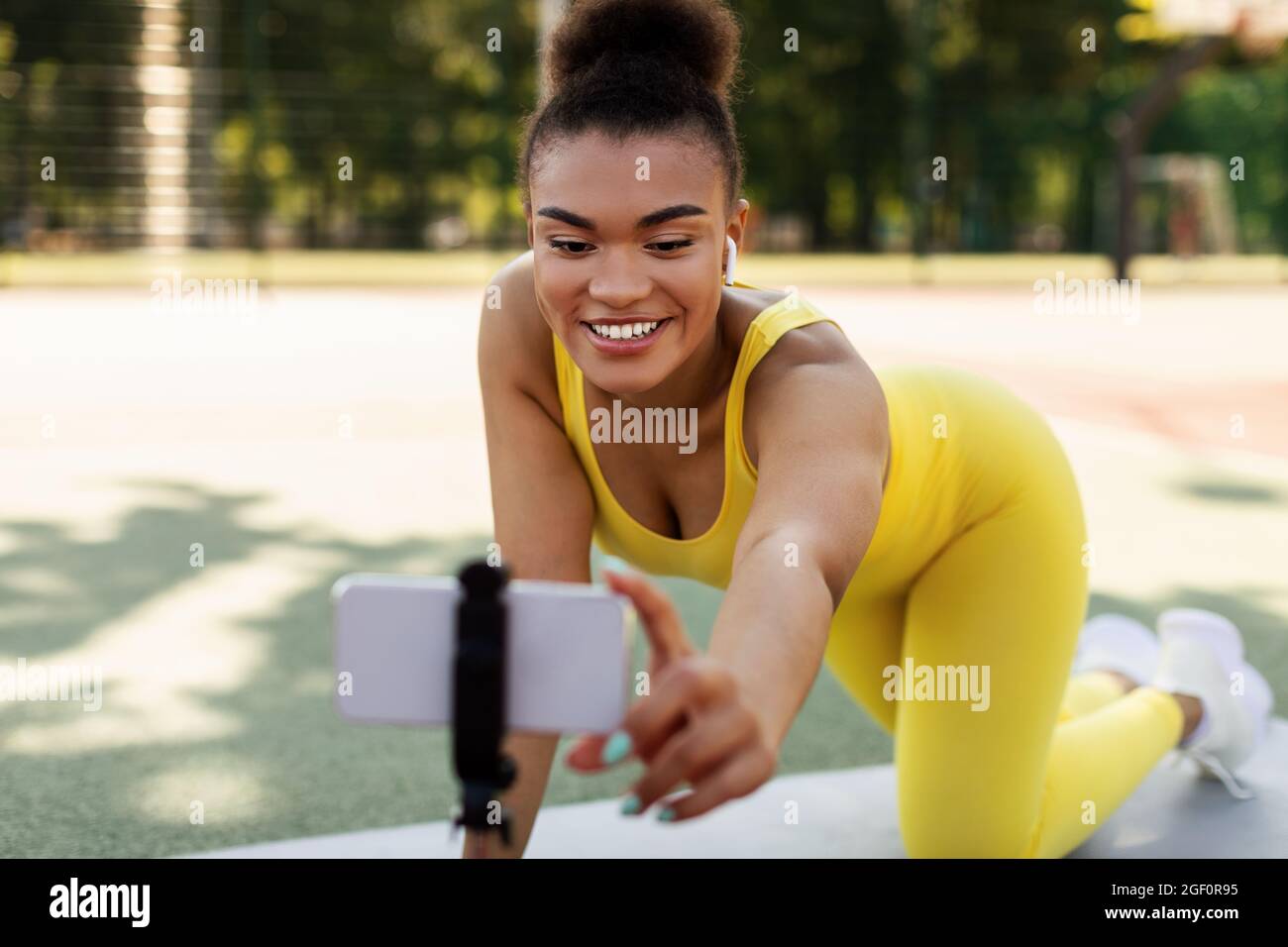 Young black woman recording exercises on smartphone outdoors Stock ...