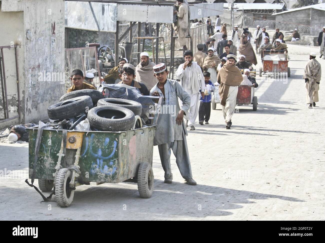 A group of boys push a cart of tires along the pedestrian walkway March ...