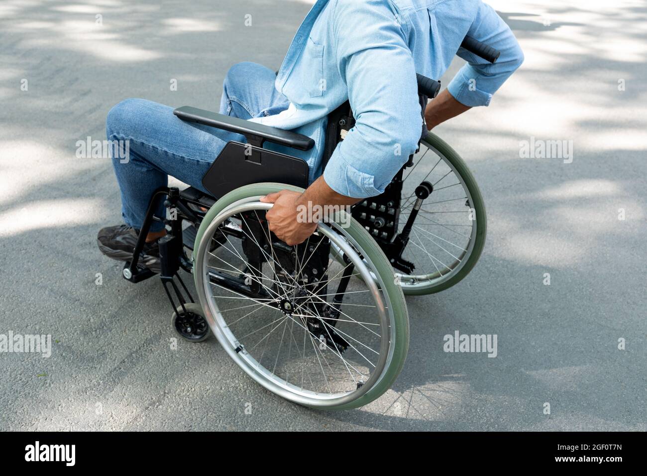 Unrecognizable young black disabled guy in wheelchair enjoying walk at ...