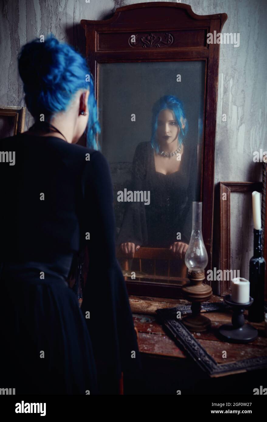 Indoors portrait of lovely goth girl in black dress. Blue-haired gothic ...