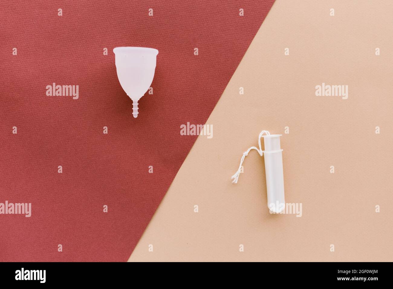 A menstrual cup and a tampon on a red and peach background Stock Photo ...