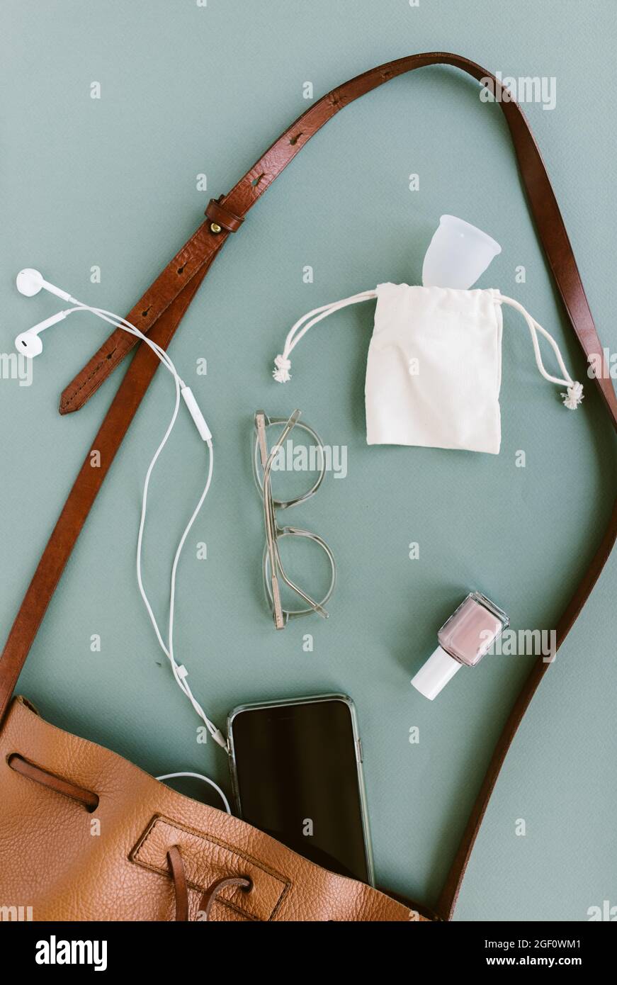 A top view of the contents of a woman's purse spilling out on a mint ...