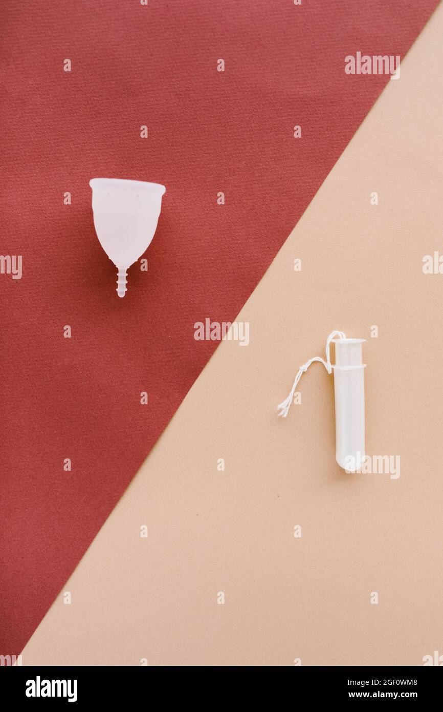 A menstrual cup and a tampon on a red and peach background Stock Photo ...