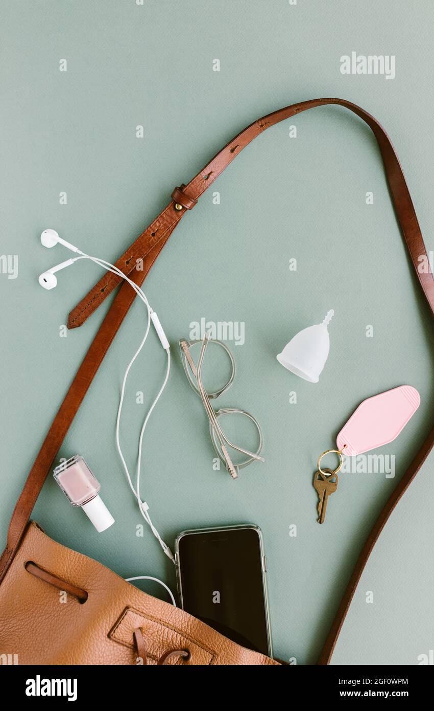 A top view of the contents of a woman's purse spilling out on a mint ...