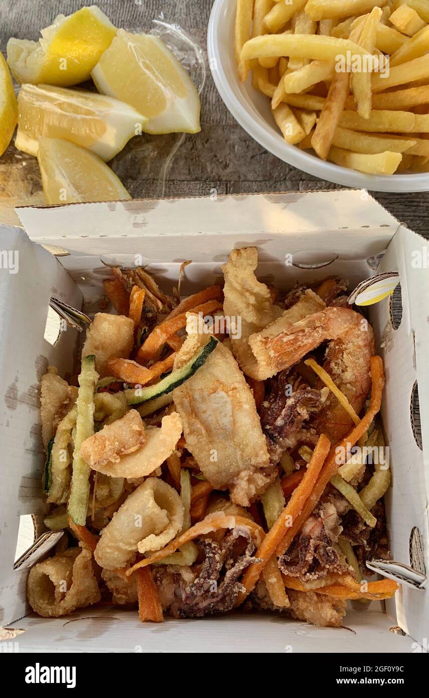 Mixed fried fish with potatoes and lemon. Directly above Stock Photo ...