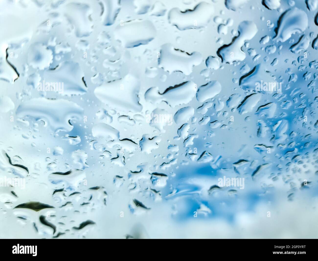 Rain drops running down a window in a close up view Stock Photo - Alamy