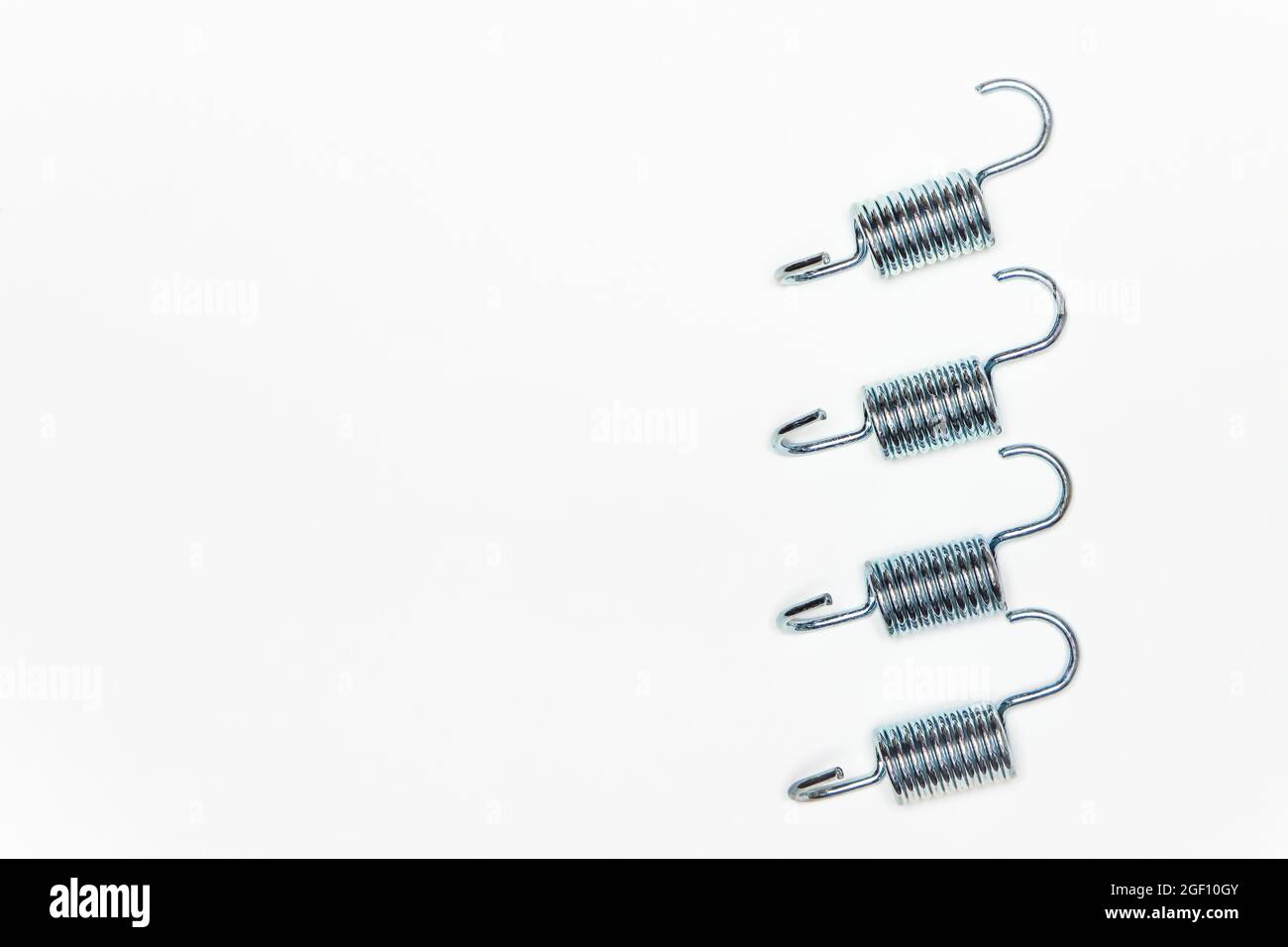 Four identical metal springs, parts for car repair. A set of spare ...