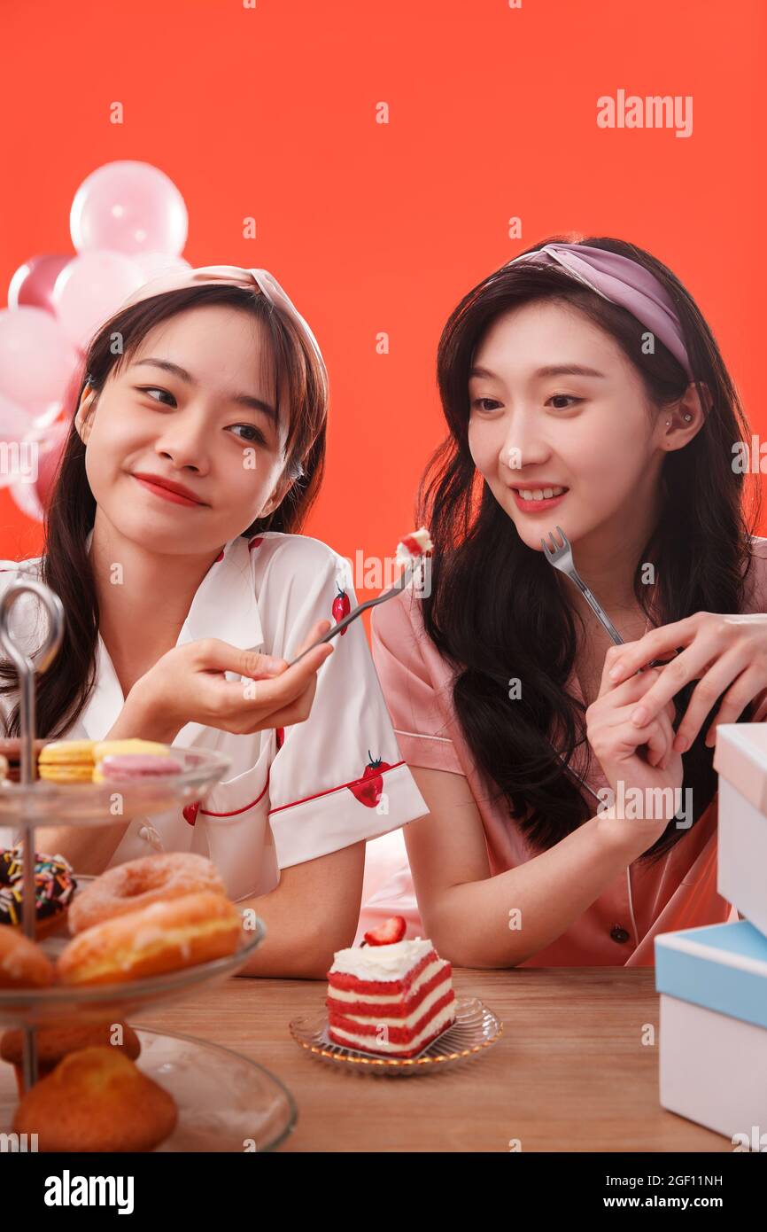 Beautiful young girlfriends to eat dessert Stock Photo - Alamy