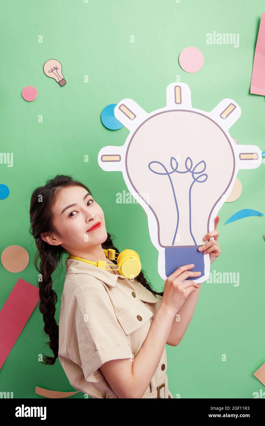 Young girl with a light bulb icon Stock Photo - Alamy