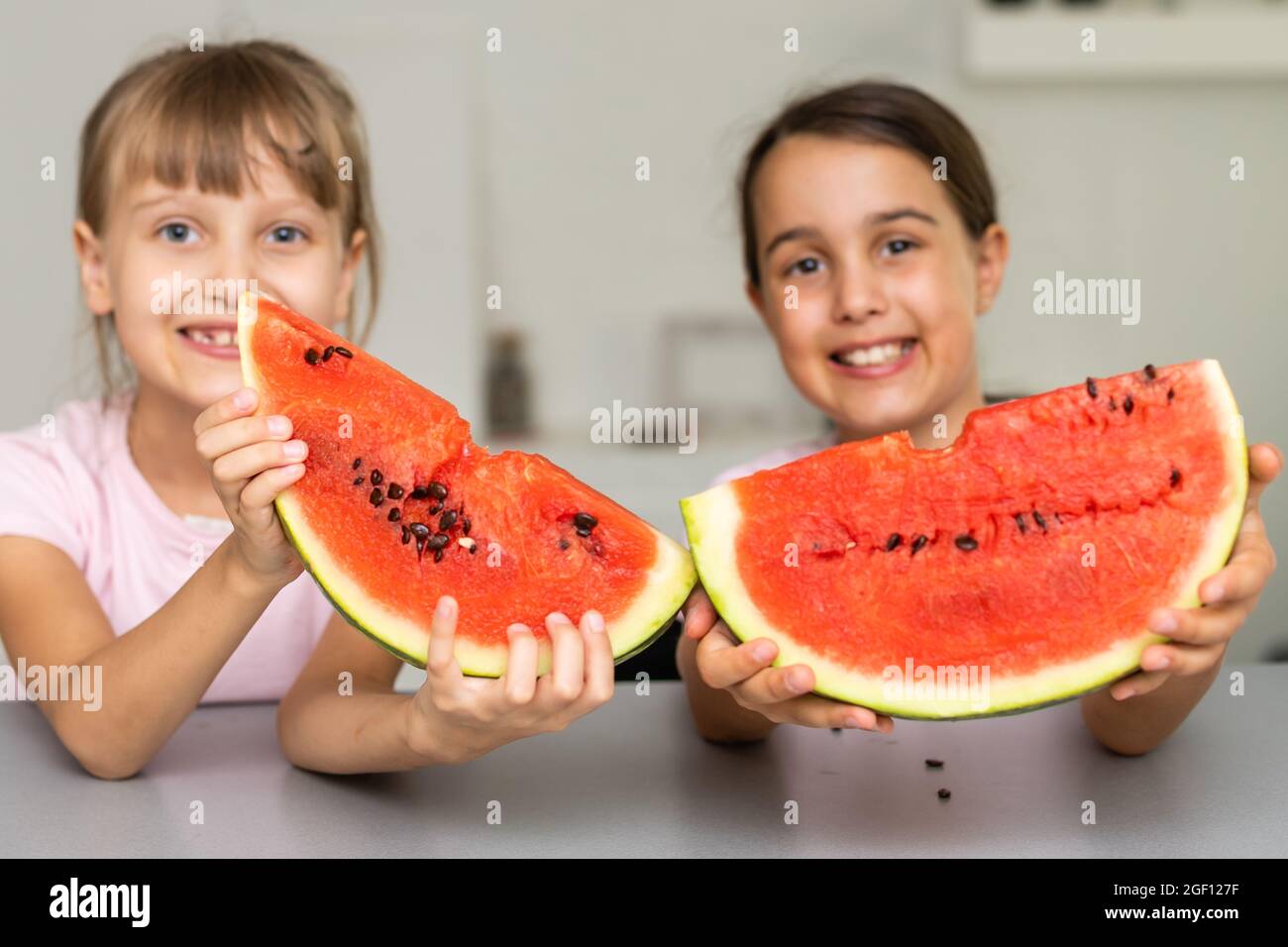 Two girls eating Watermelon isolated at home Stock Photo - Alamy