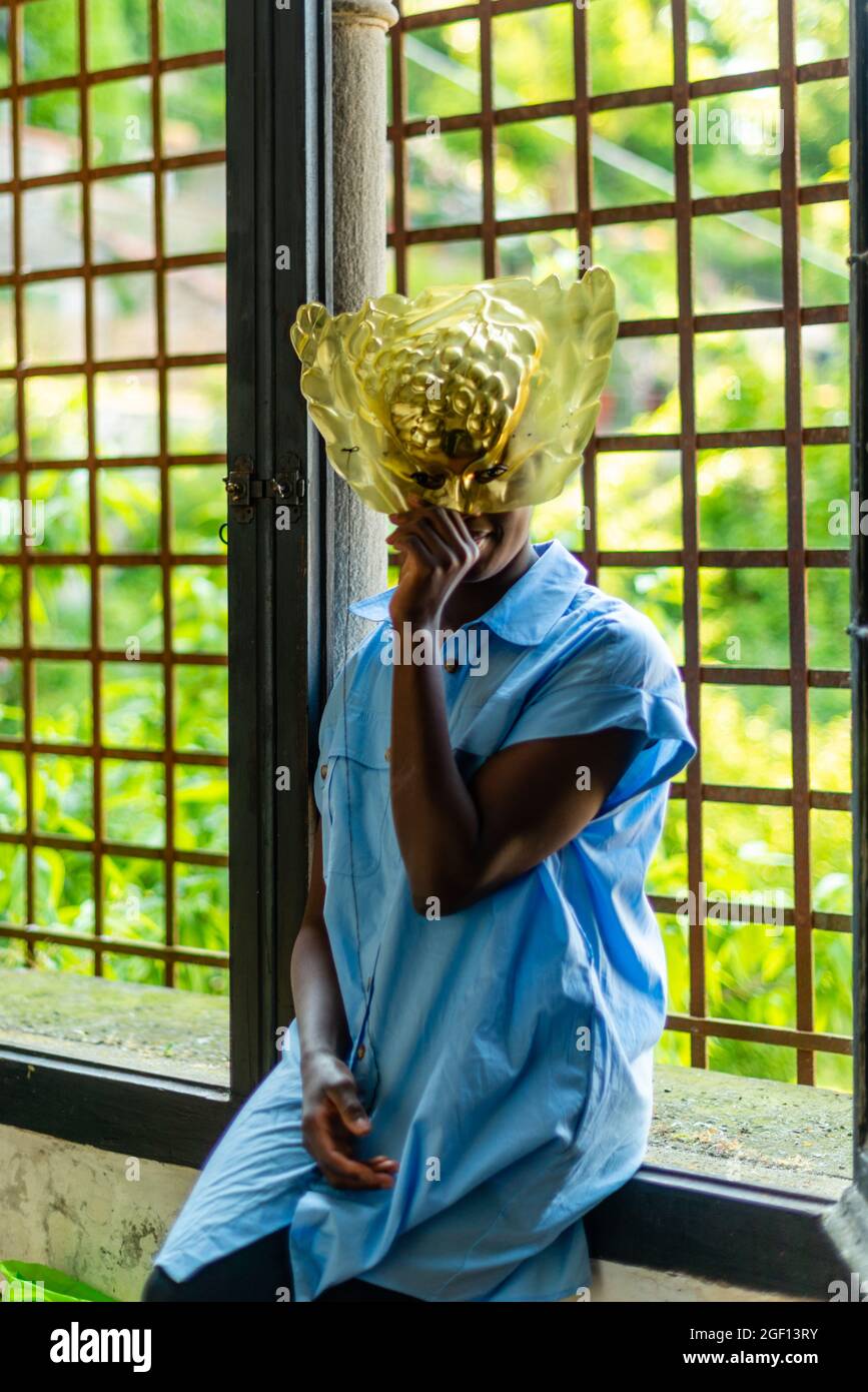 A young Black man covering his face with the Italian traditional volto ...
