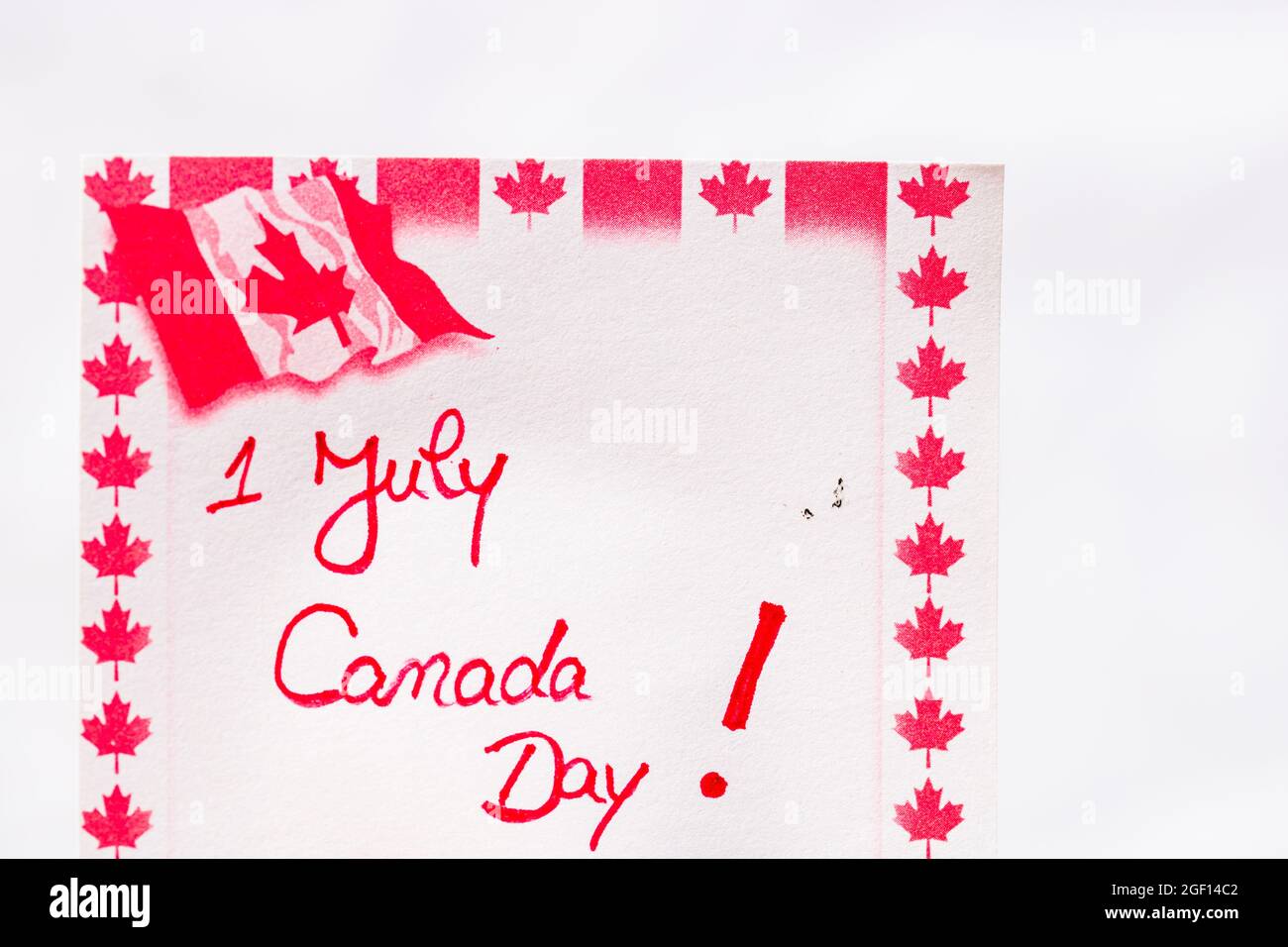 A handwriting saying 'Canada day 1 July' on a paper with Canada flag ...
