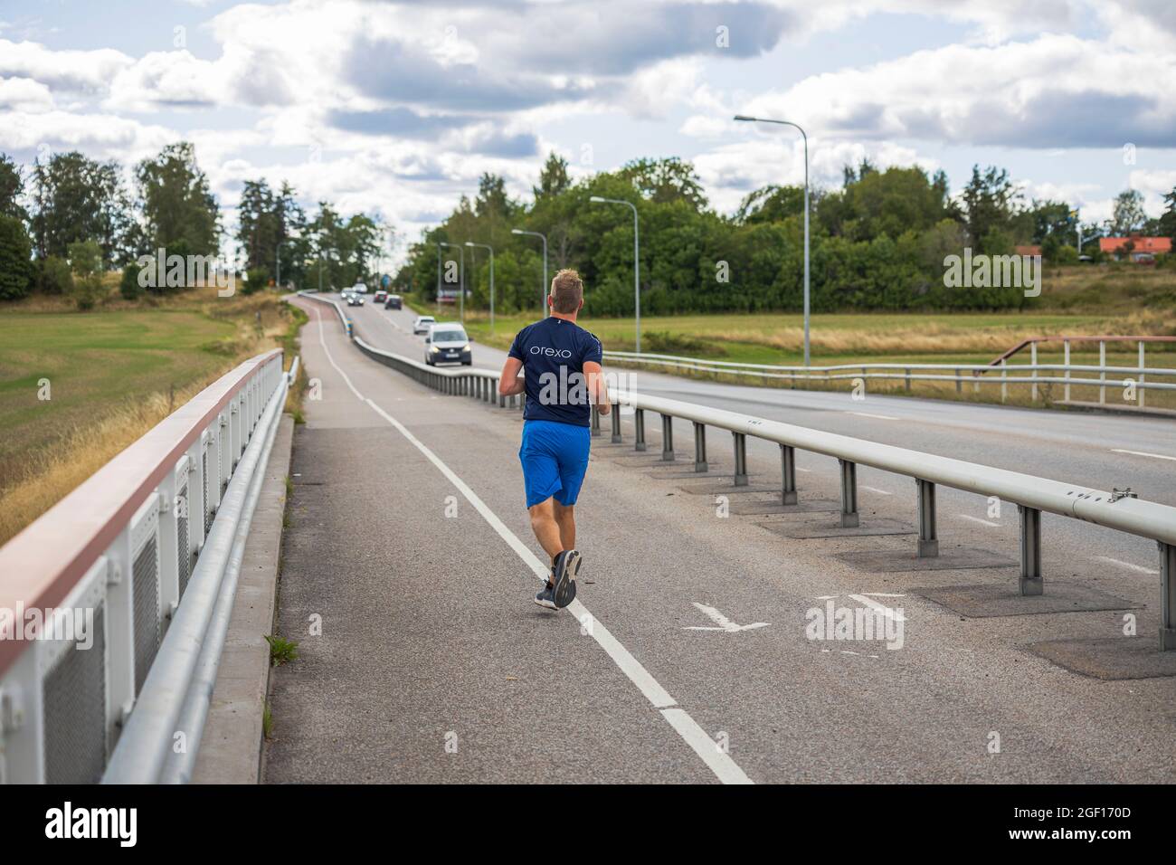 Close up view of man running along asphalt road. Healthy lifestyle ...