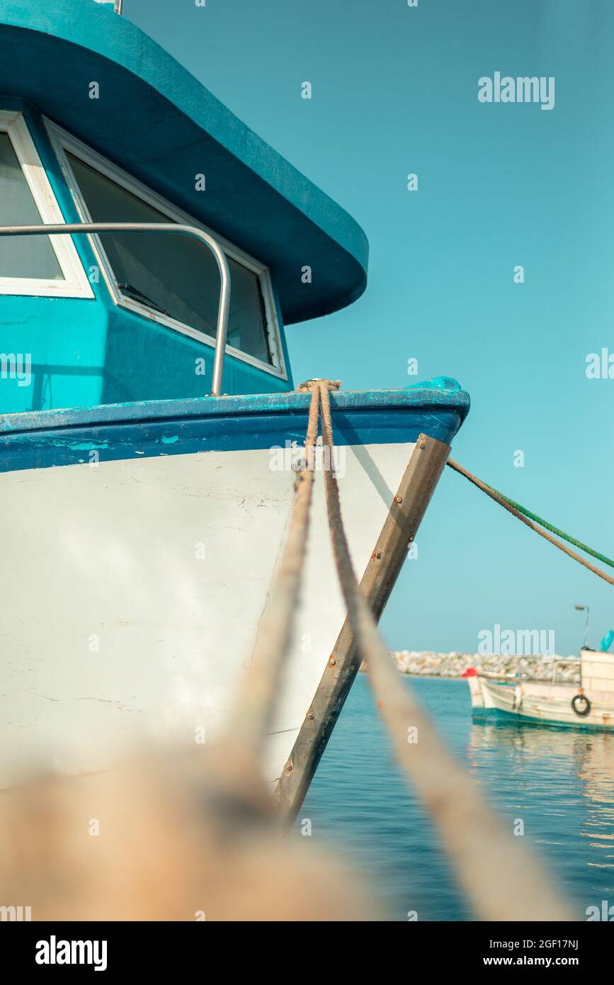 Harbored medium size fishing boat with ropes on a dock Stock Photo - Alamy