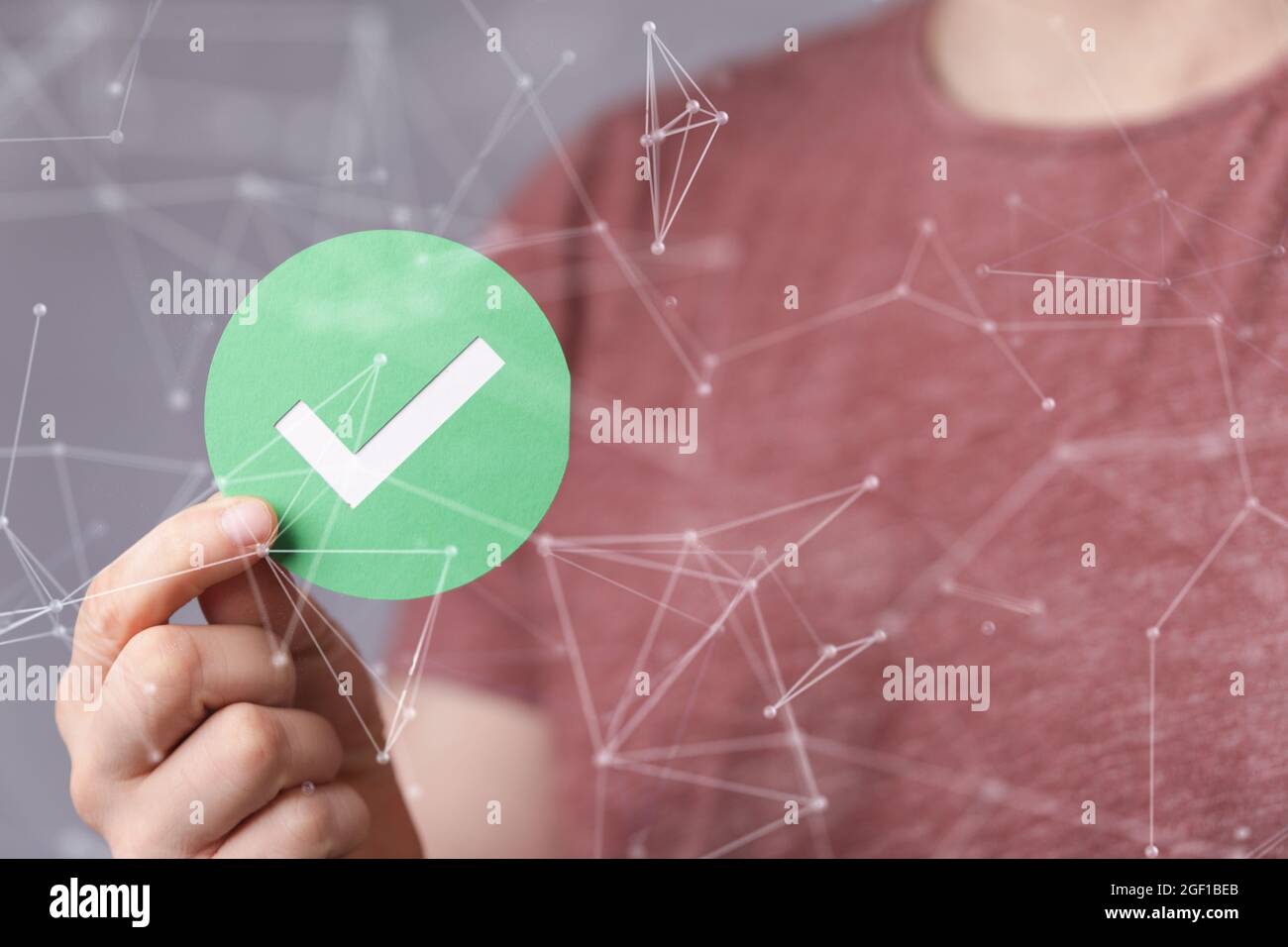 A person holding a green checkmark sign Stock Photo - Alamy