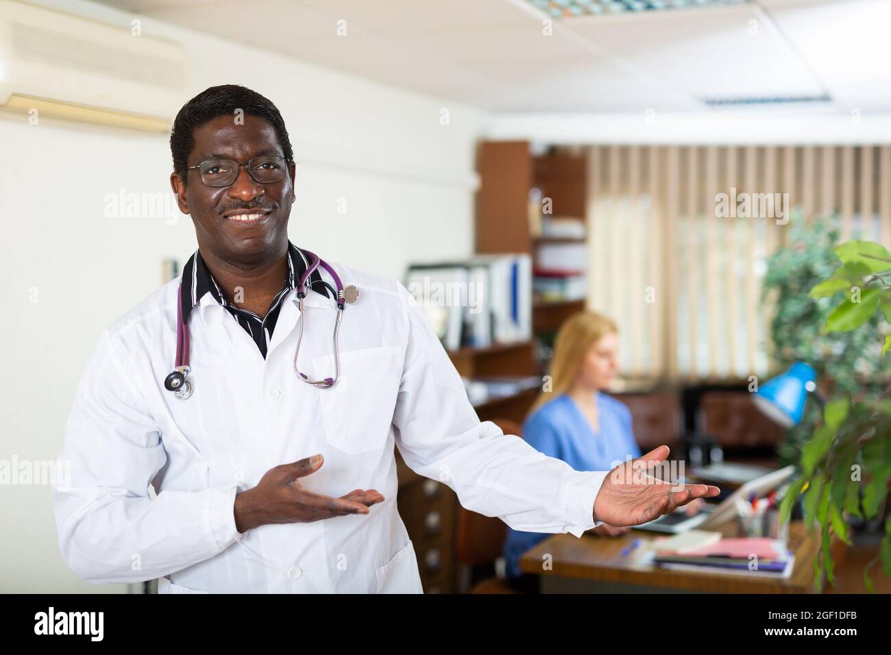 Smiling african american doctor welcoming to medical office Stock Photo ...