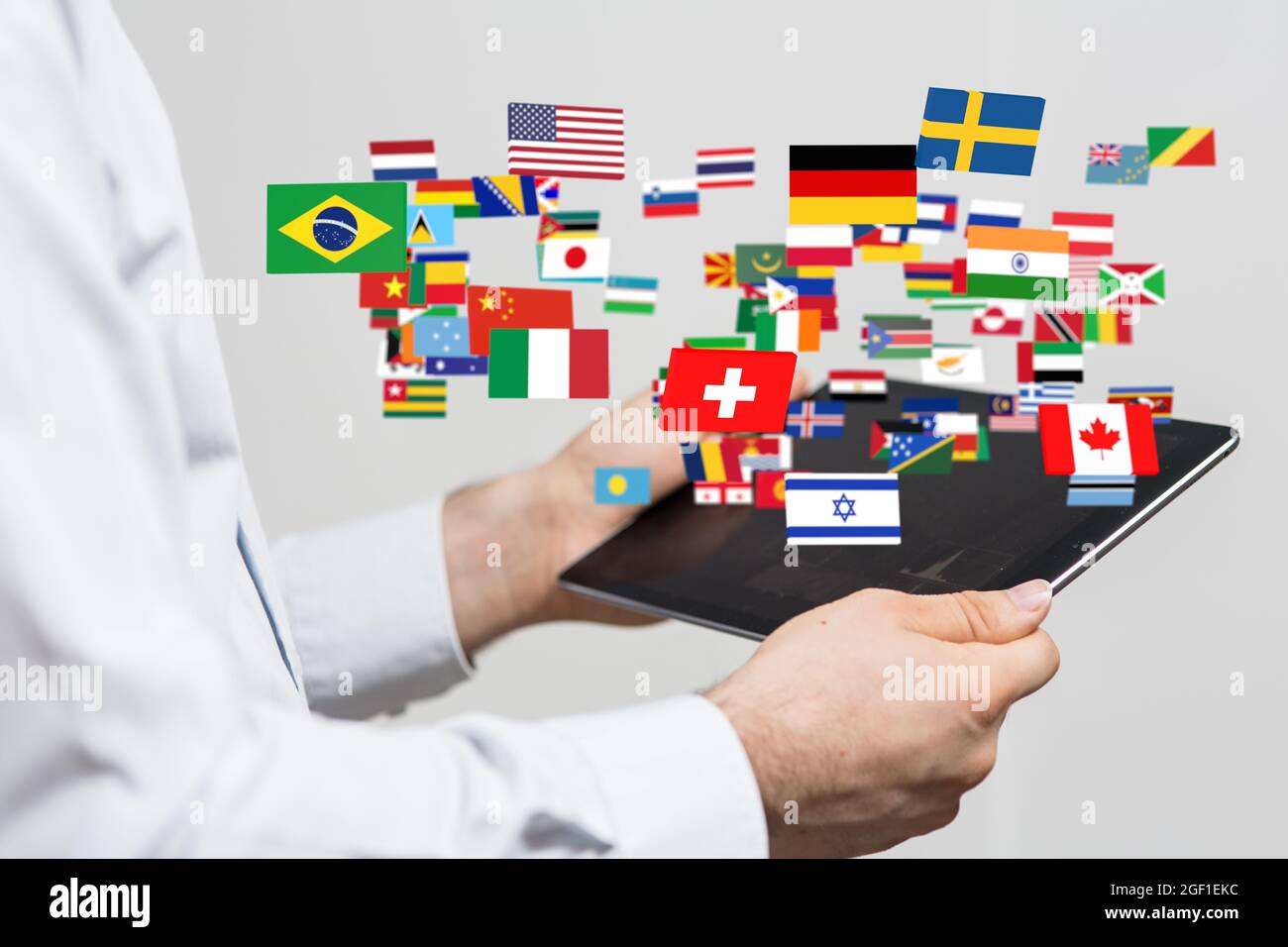 A man holding the virtual 3D national flags of different countries ...