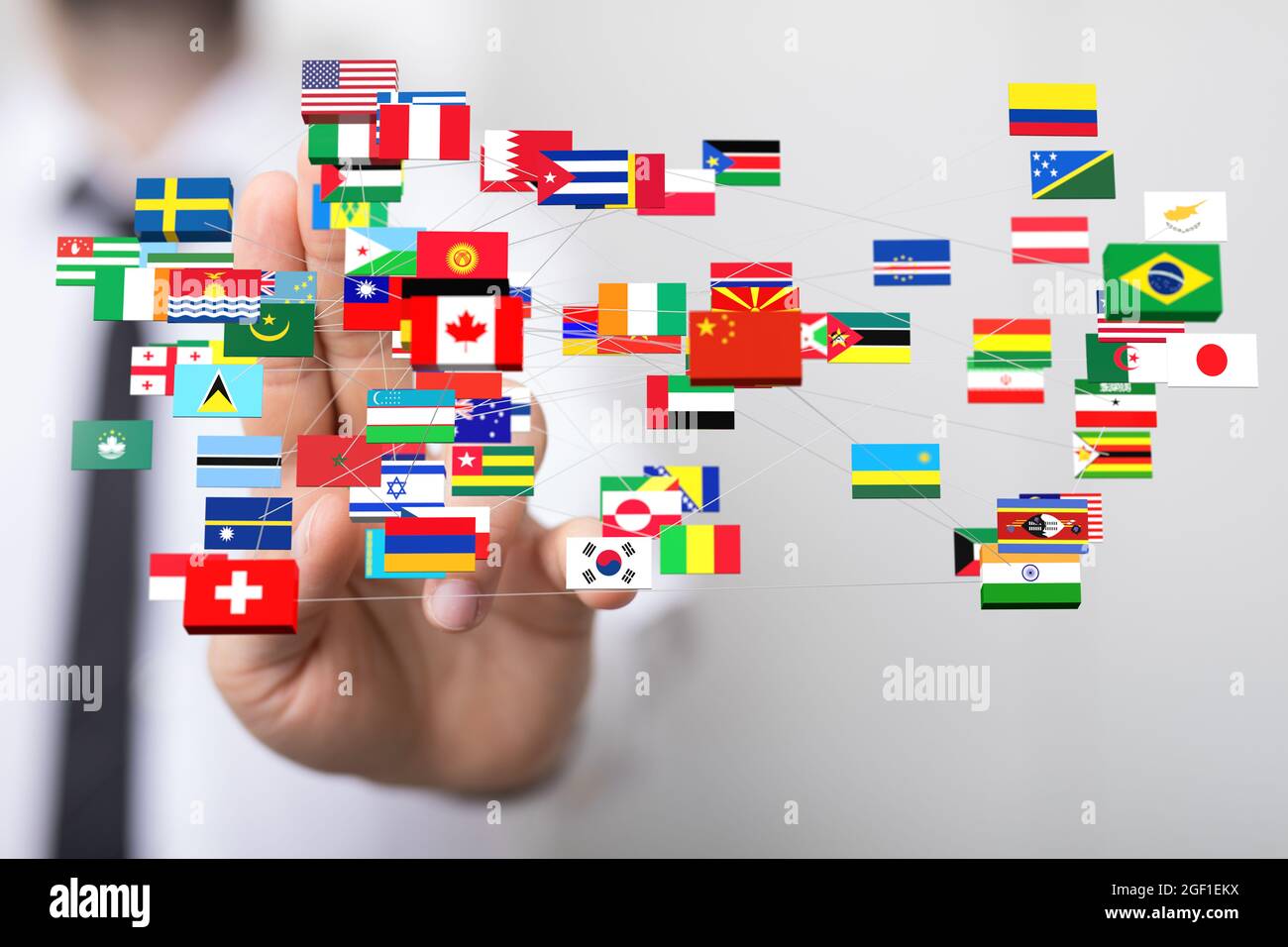 A man holding the virtual 3D national flags of different countries ...