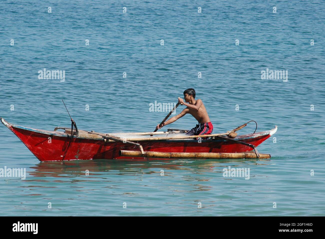 MINDORO, PHILIPPINES - Aug 04, 2006: A young fisherman is driving a ...