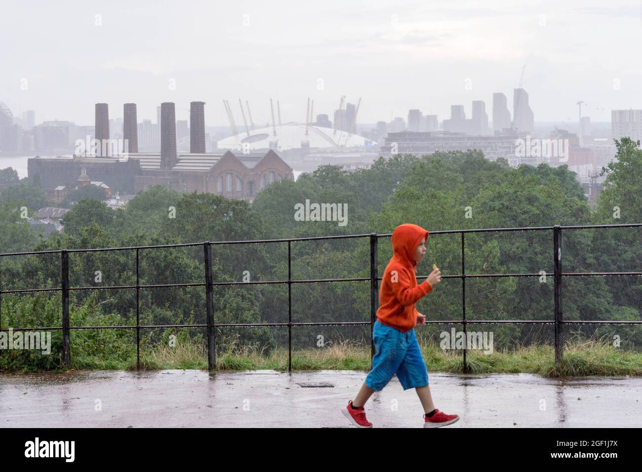 tourist in orange top and shoes walk in the down pour heavy rain in ...