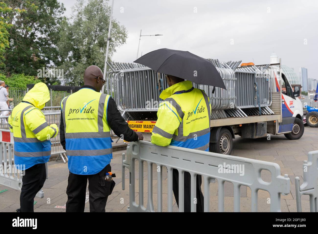 Three security guards with one umbrella at Big Half Marathon UK 2021 ...