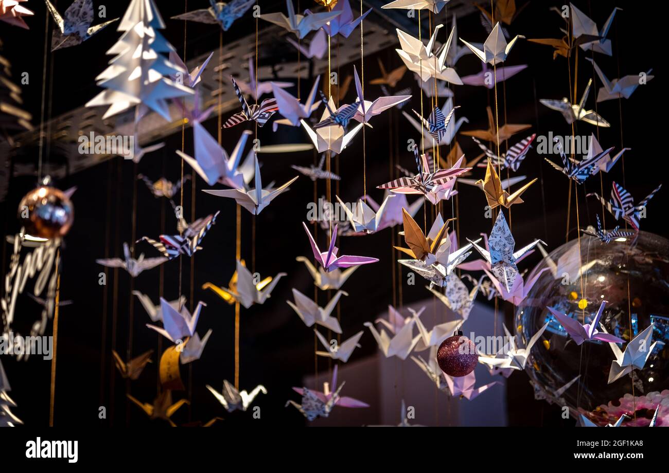 Lots of origami swans hanging from the roof, seen from underneath in a ...
