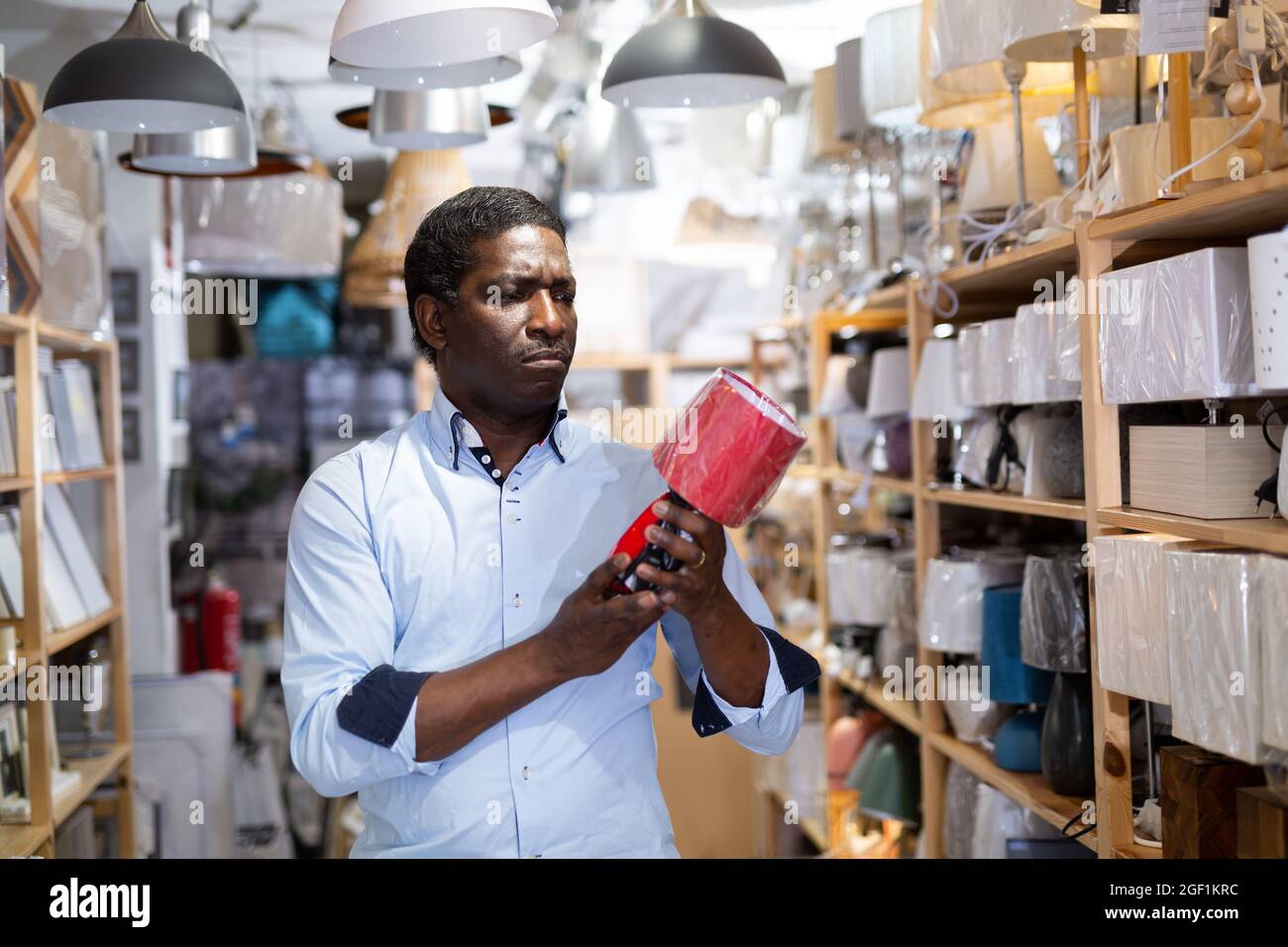 Man is choosing new table lamp for her home in store Stock Photo - Alamy