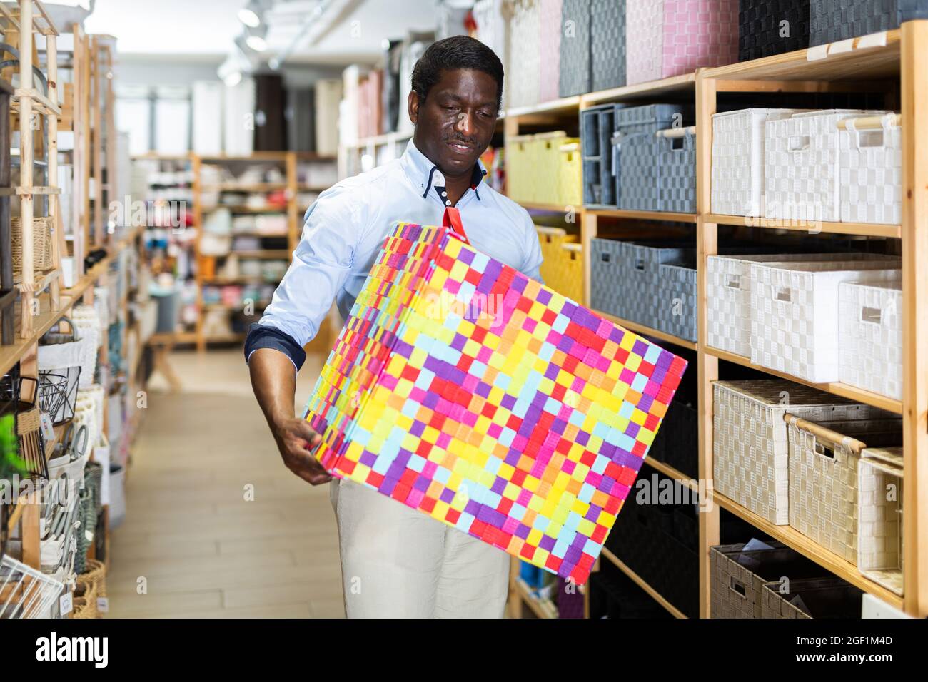 Smiling african american man choosing storage box at store Stock Photo ...