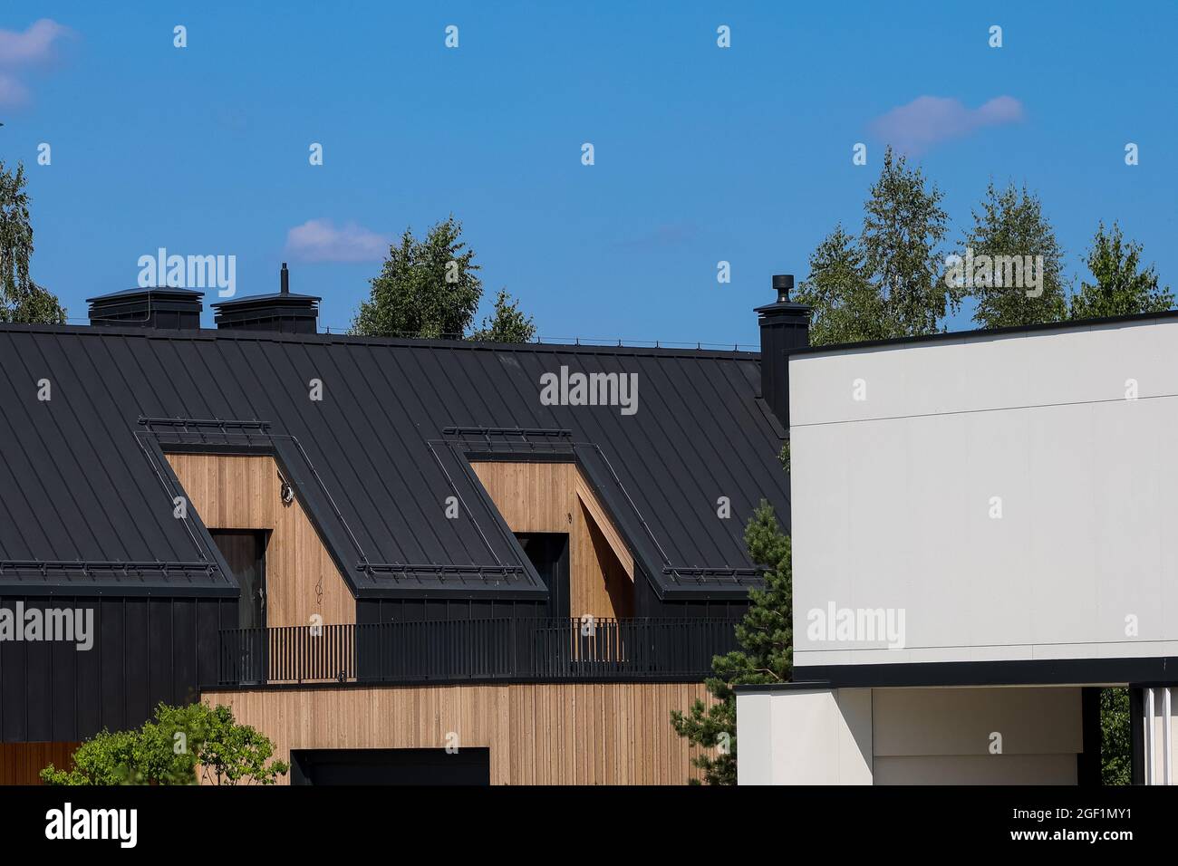 A modern family home with a trendy design. Gray roof, sand walls Stock ...