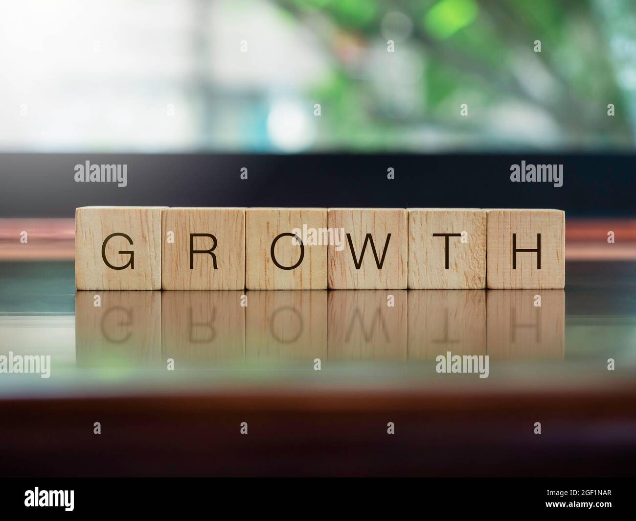 Growth, words on wooden cube blocks on brown wood desk and green nature ...