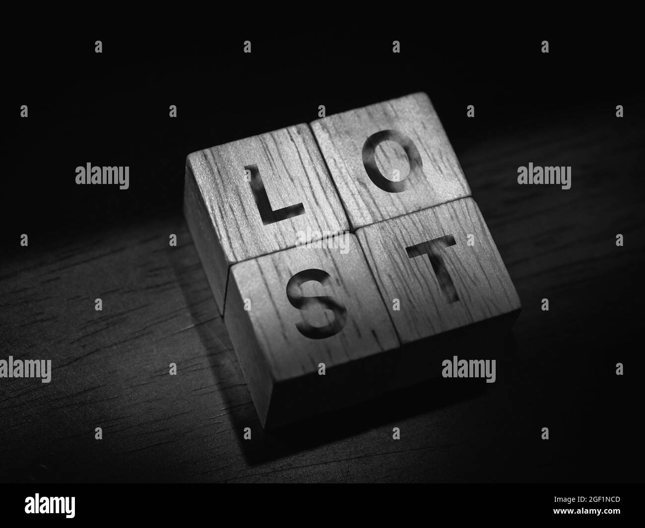Lost, word on wooden cube blocks on dark background, black and white ...