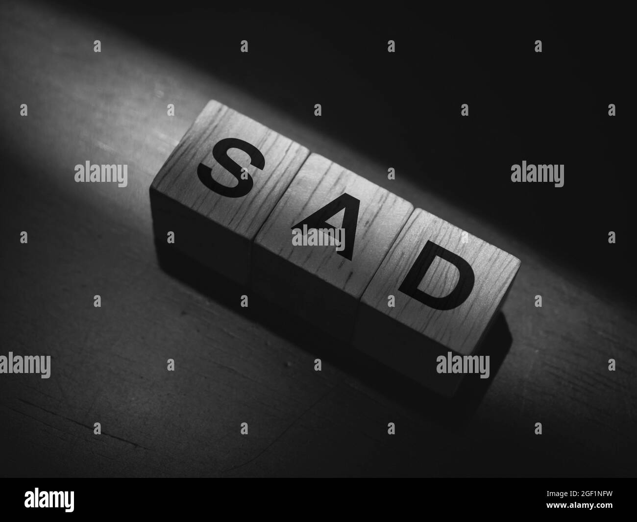 Sad, word on wooden cube blocks on dark background, black and white ...