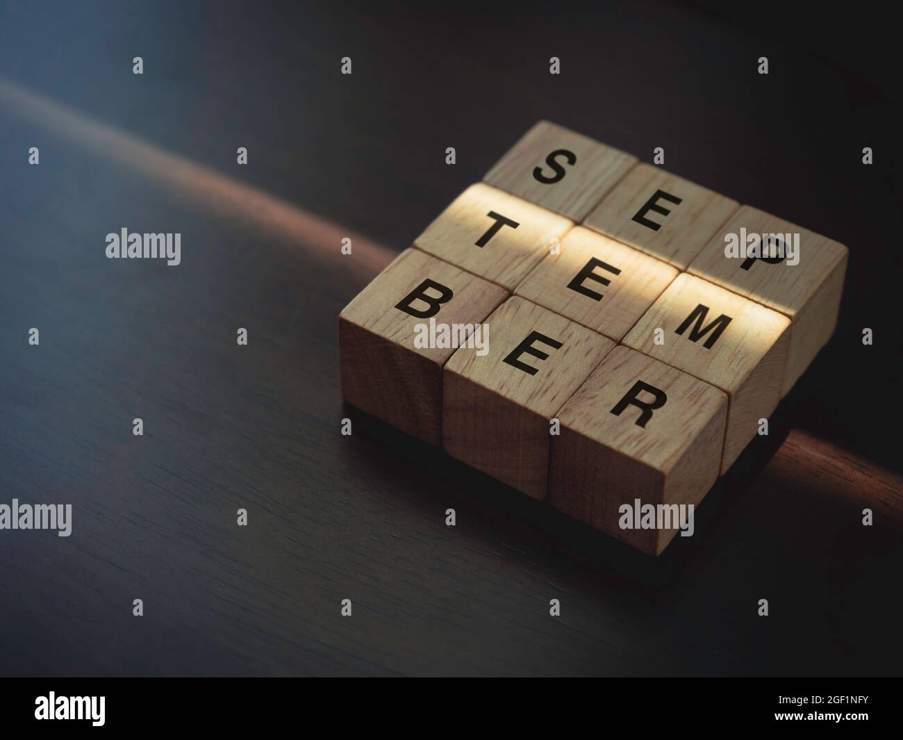 September, words on wooden cube blocks on dark brown wood background ...