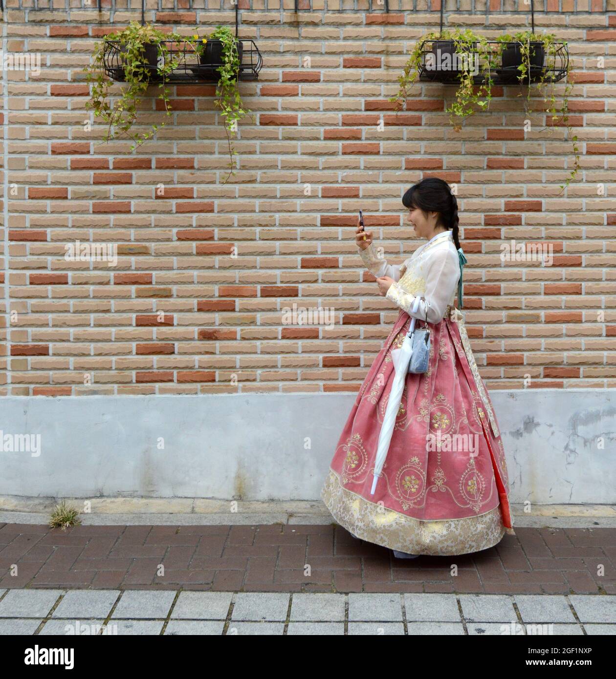 Chinese tourist dressed in traditional Korean dress in the Bukchon ...