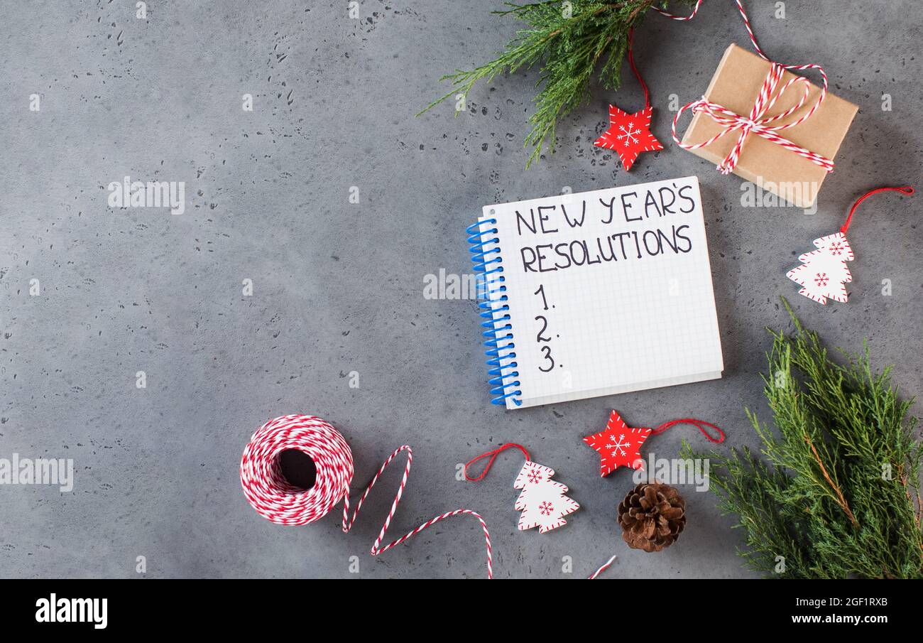 The word New Year's resolution, written in a white notebook on a gray ...