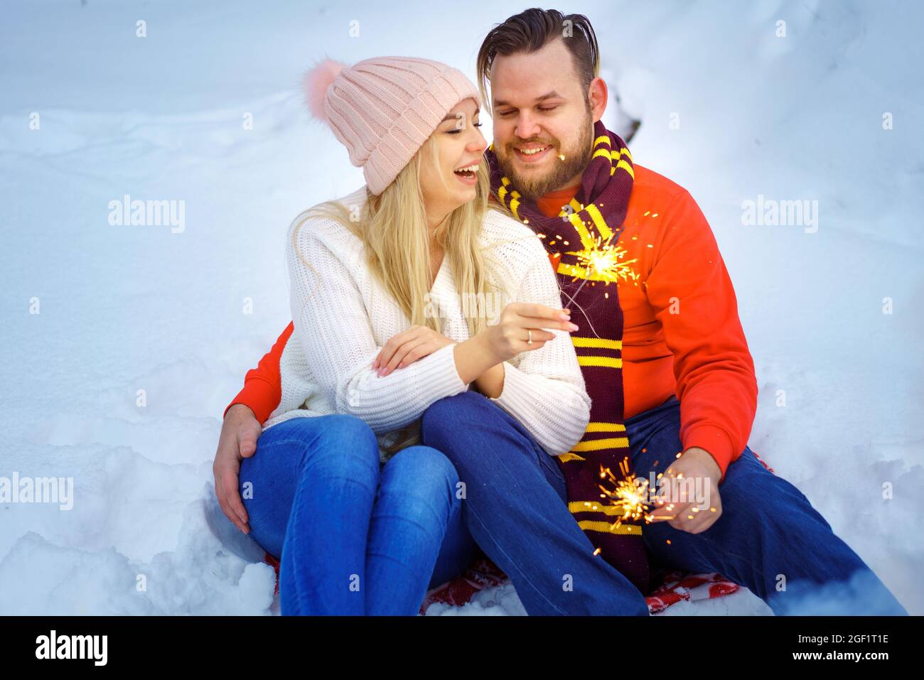 Happy couple man and woman hugging in winter in the forest by the fire ...
