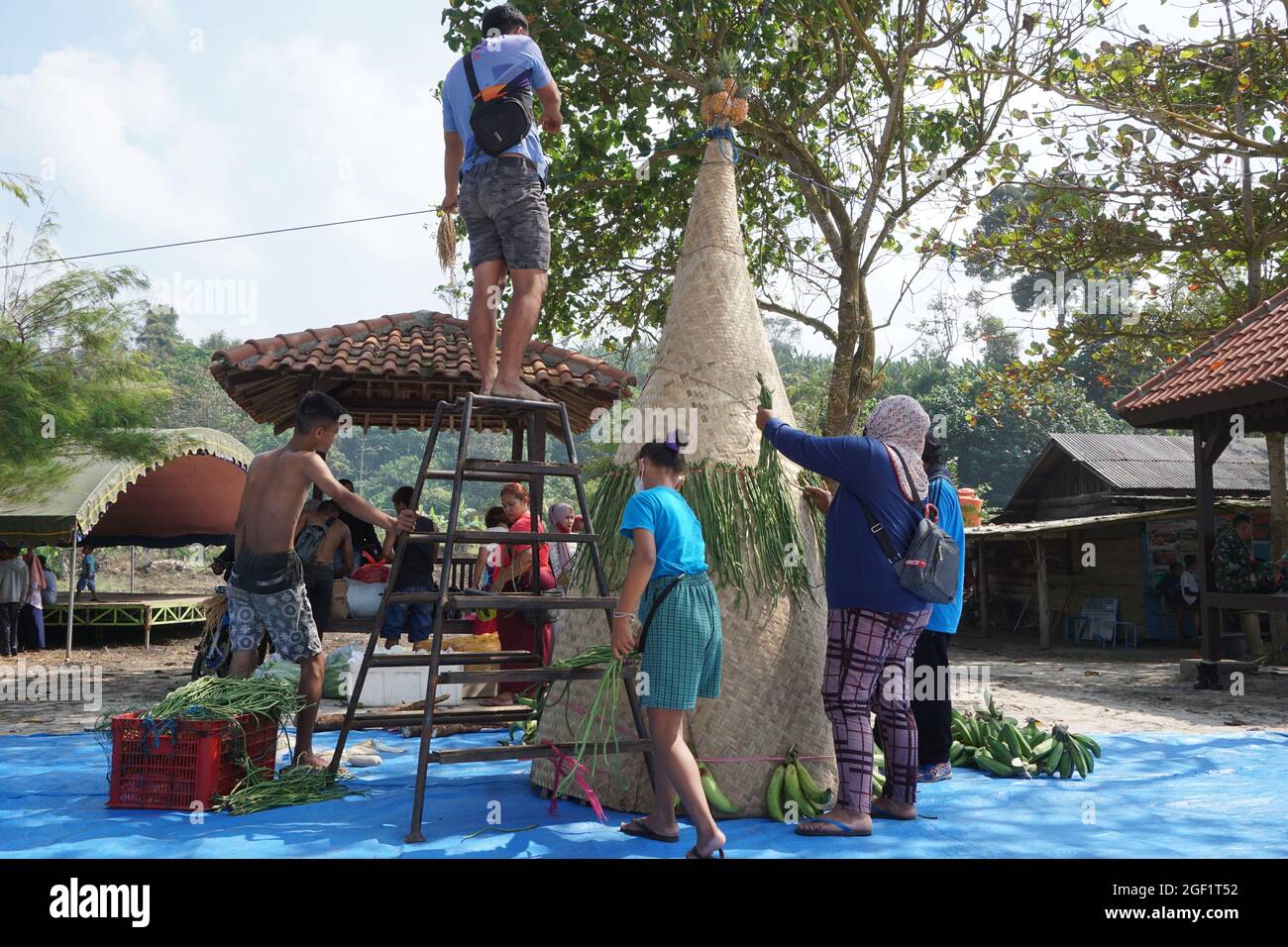 People arrange vegetables to make tumpeng sayur (vegetable cone) for ...