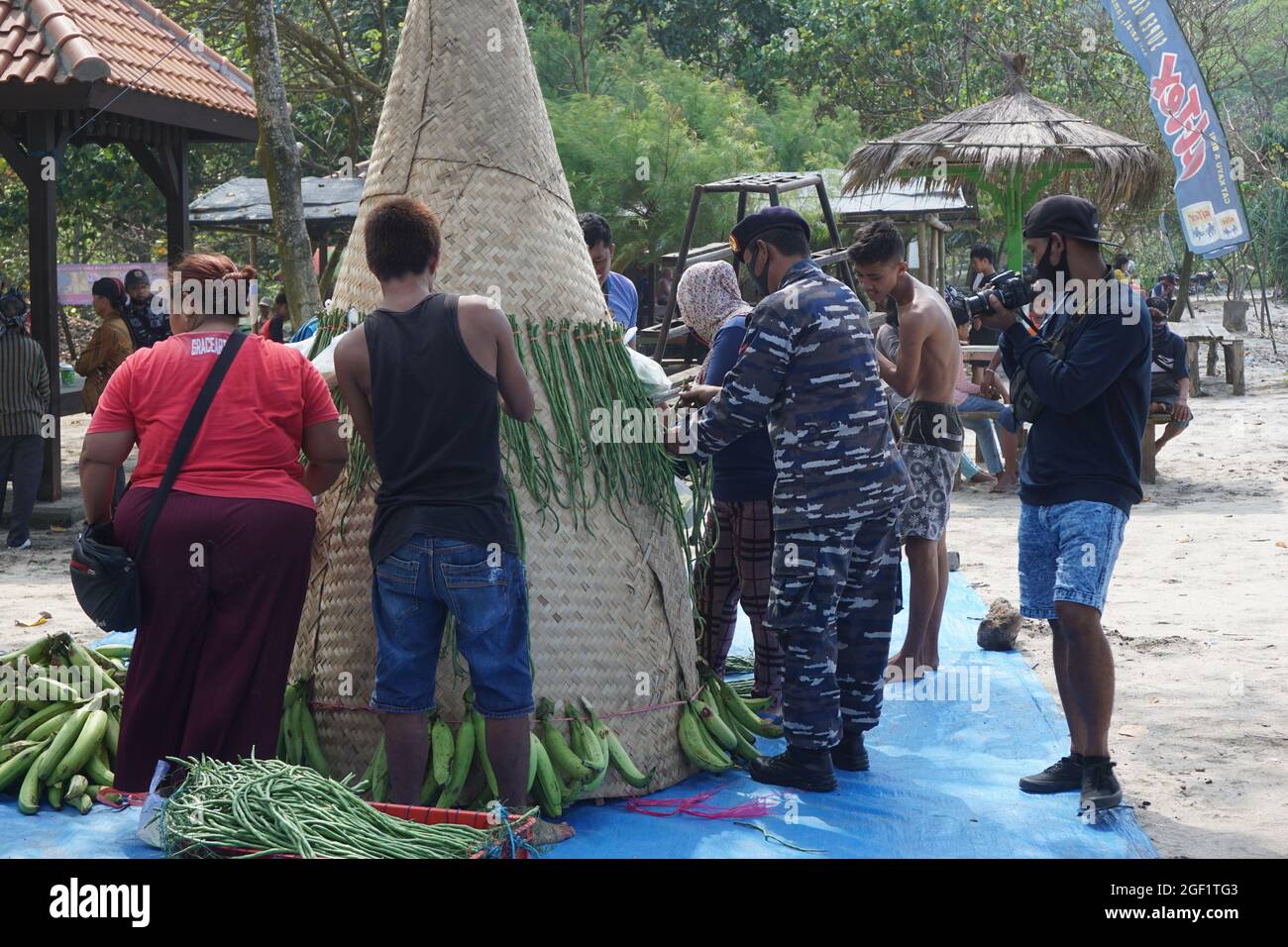 People arrange vegetables to make tumpeng sayur (vegetable cone) for ...