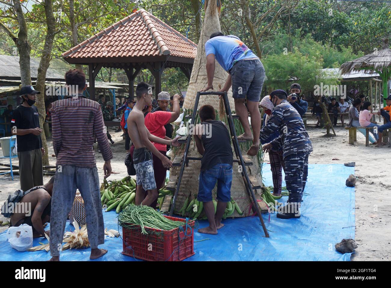 People arrange vegetables to make tumpeng sayur (vegetable cone) for ...