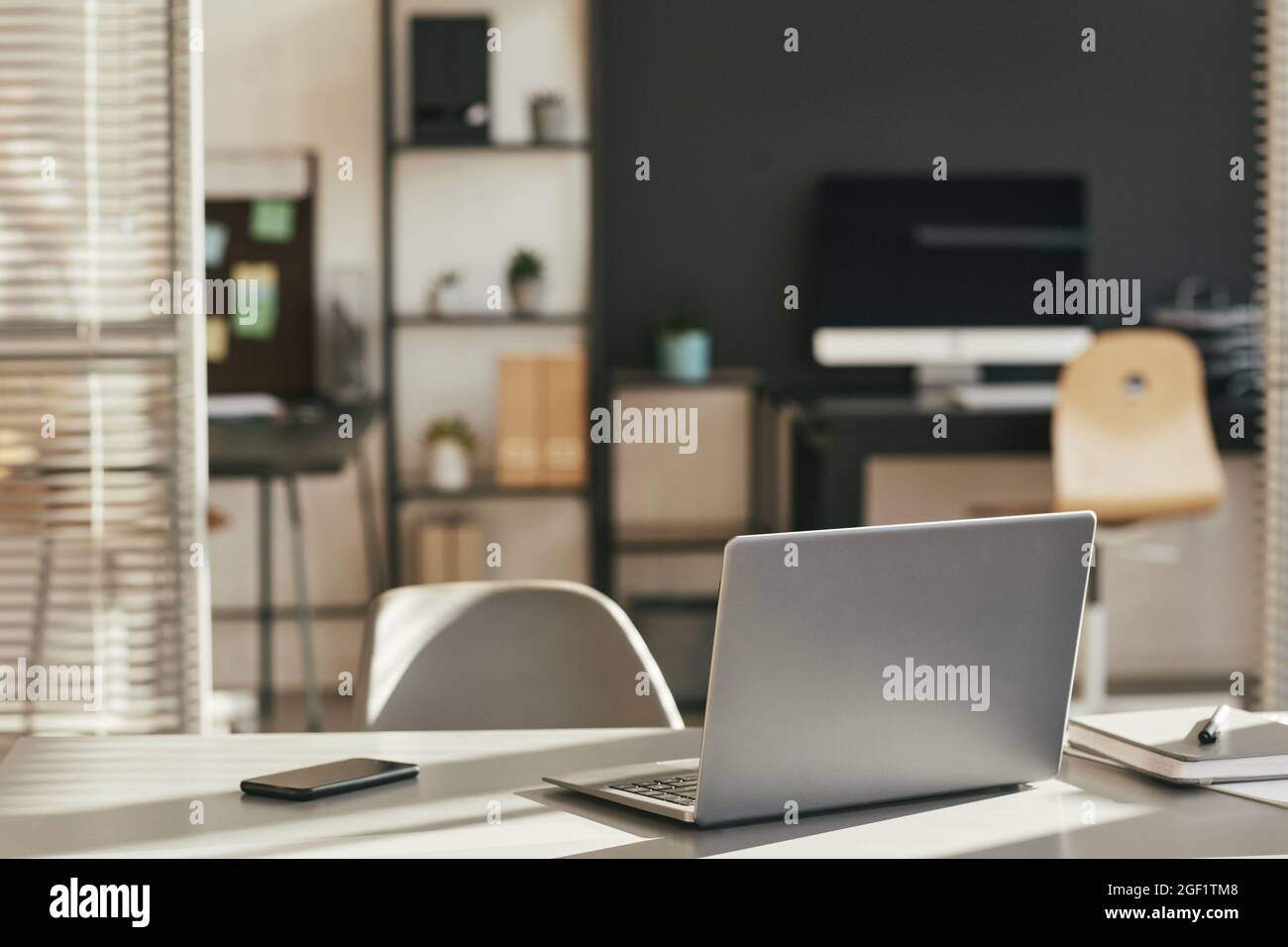 Background image of minimal home office desk lit by sunlight with focus ...