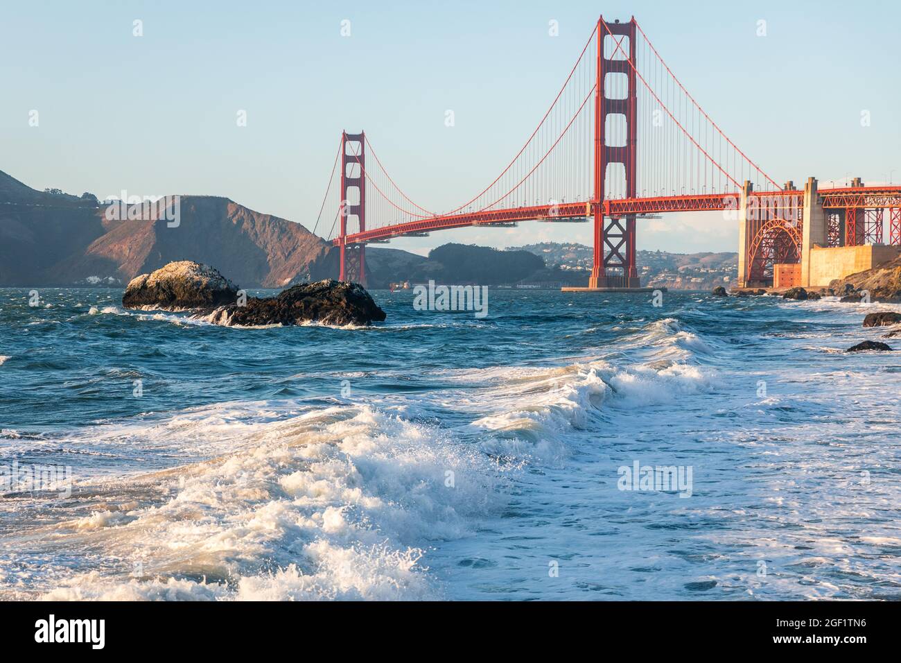 Landscape of Golden Gate bridge over sea horizon from Baker beach at sunset, San Francisco ...