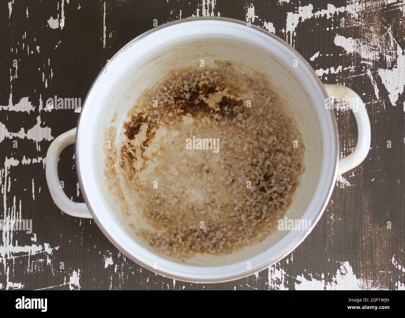 Top view of pan with burnt bottom after cooking porridge on the brown ...