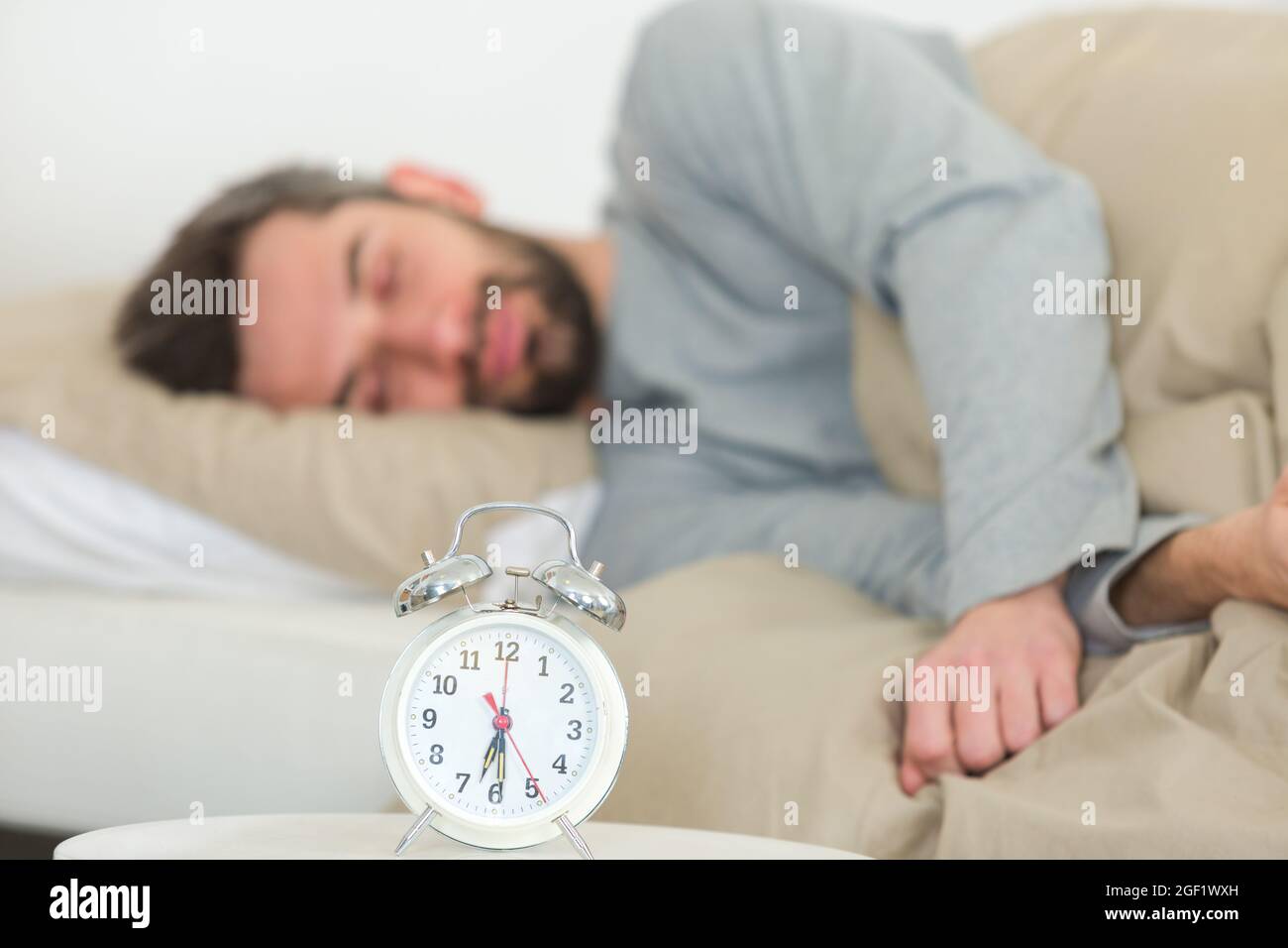 portrait of man waking up with an alarm Stock Photo - Alamy