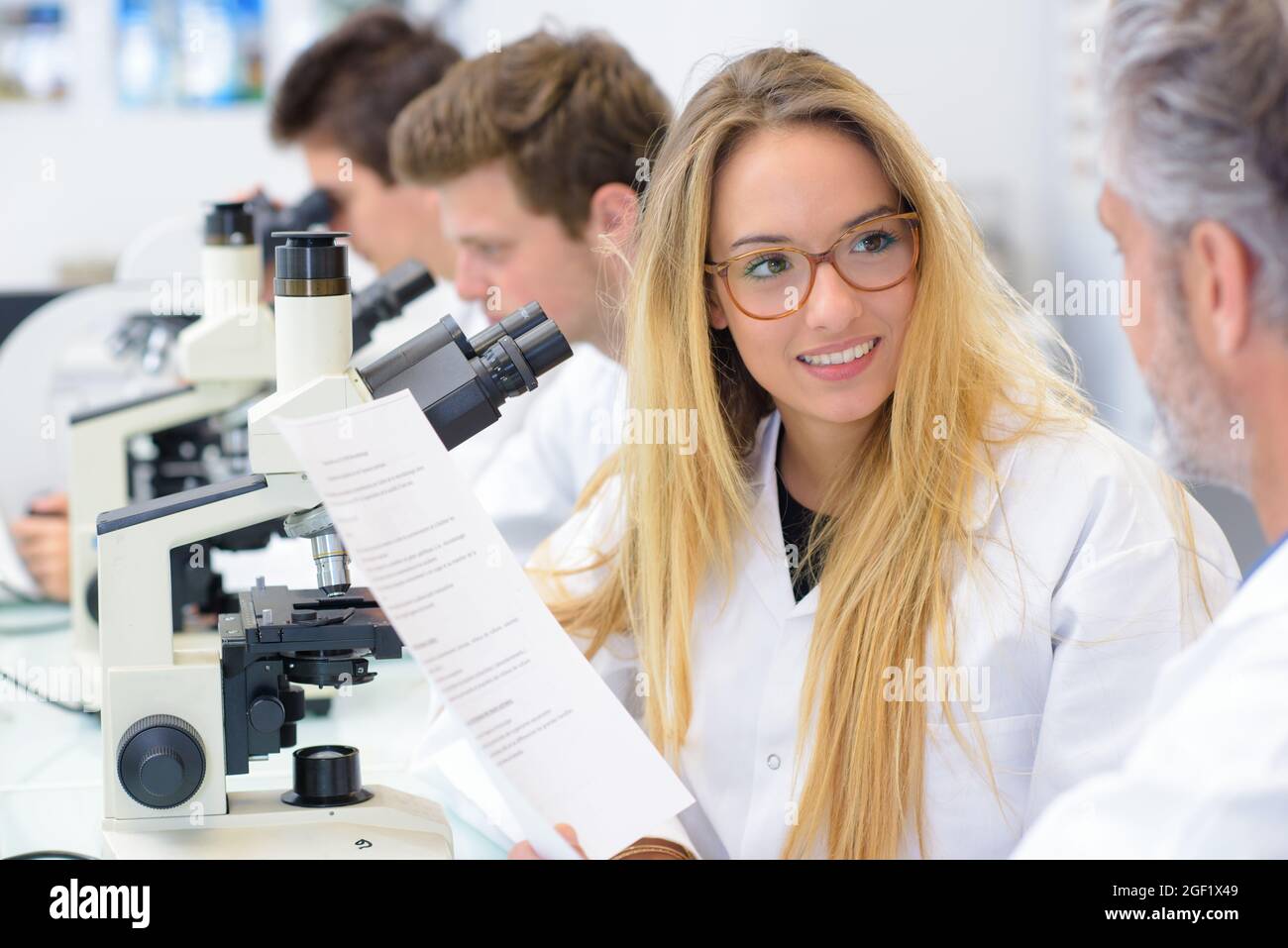 Smiling science student talking with teacher Stock Photo - Alamy