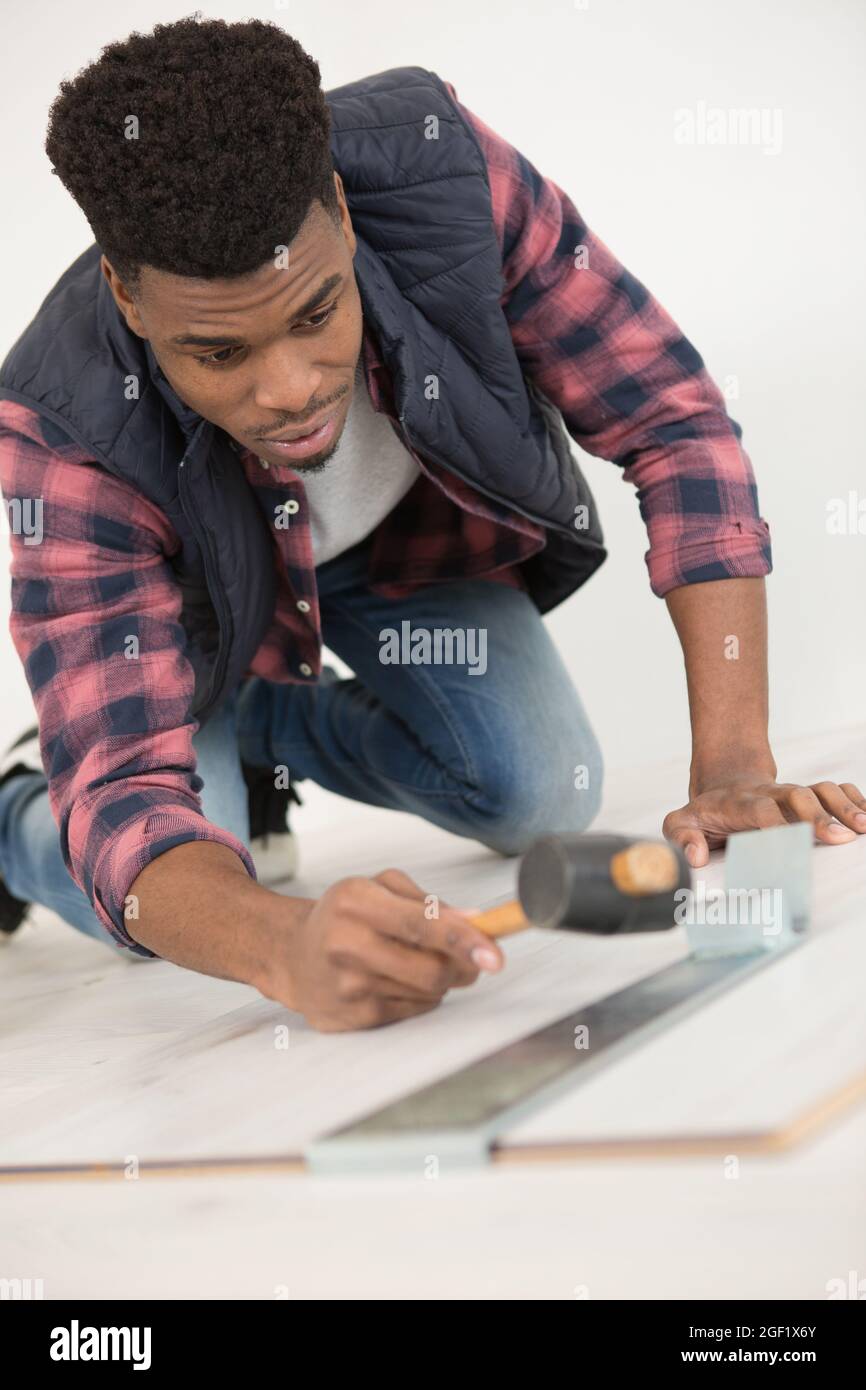 a handyman installing wooden floor Stock Photo - Alamy